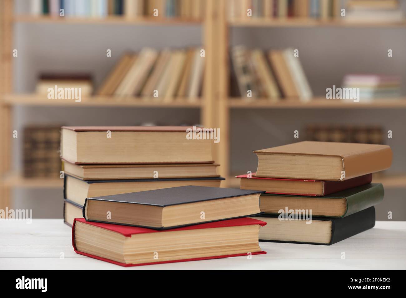 Many books on white table in library Stock Photo - Alamy