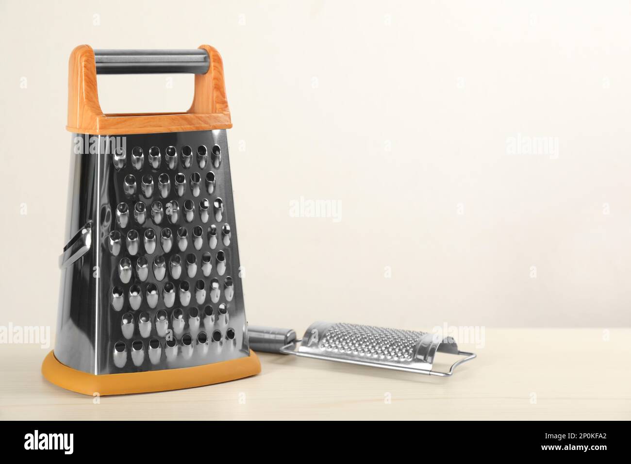 Modern graters on white wooden table. Space for text Stock Photo - Alamy