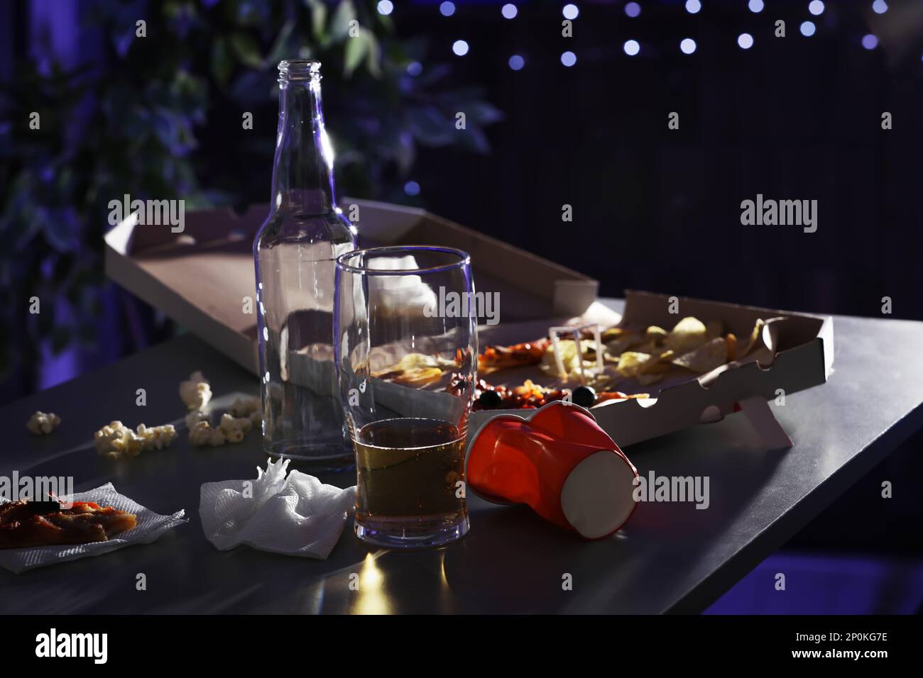 Messy table with beer and food leftovers indoors. After party chaos ...