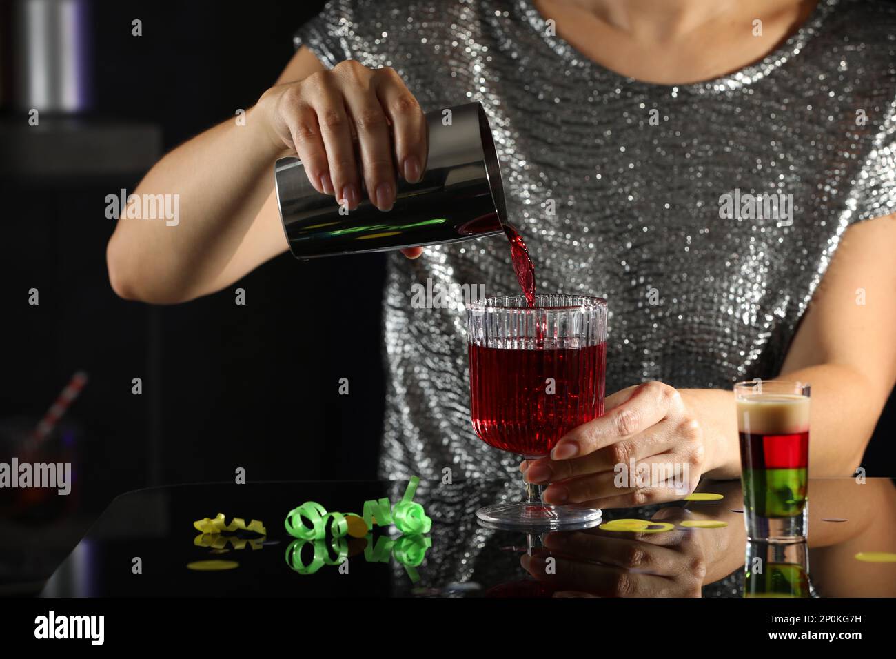 Woman pouring cocktail into glass indoors, closeup Stock Photo - Alamy