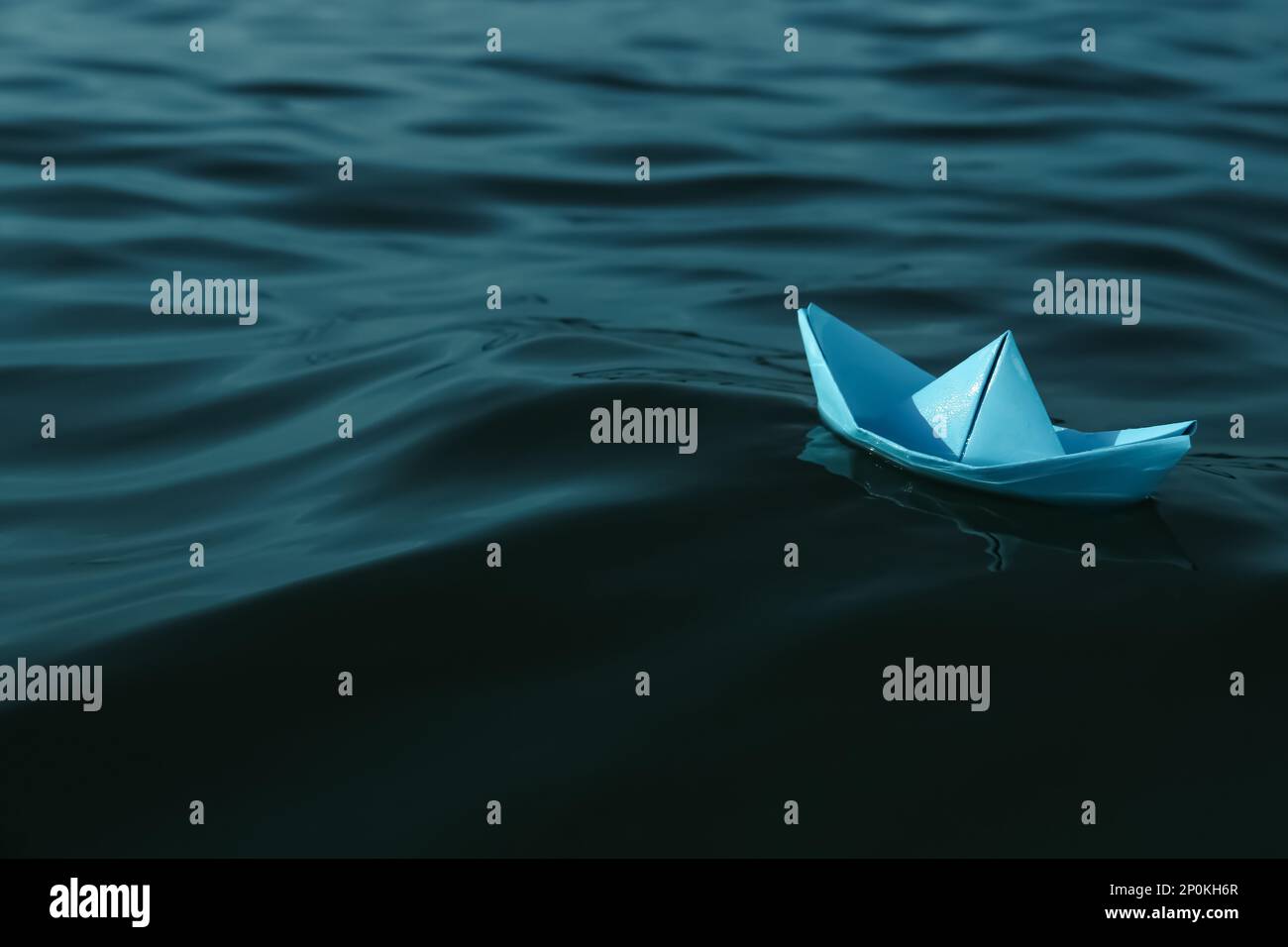 Light blue paper boat floating on river, space for text Stock Photo - Alamy