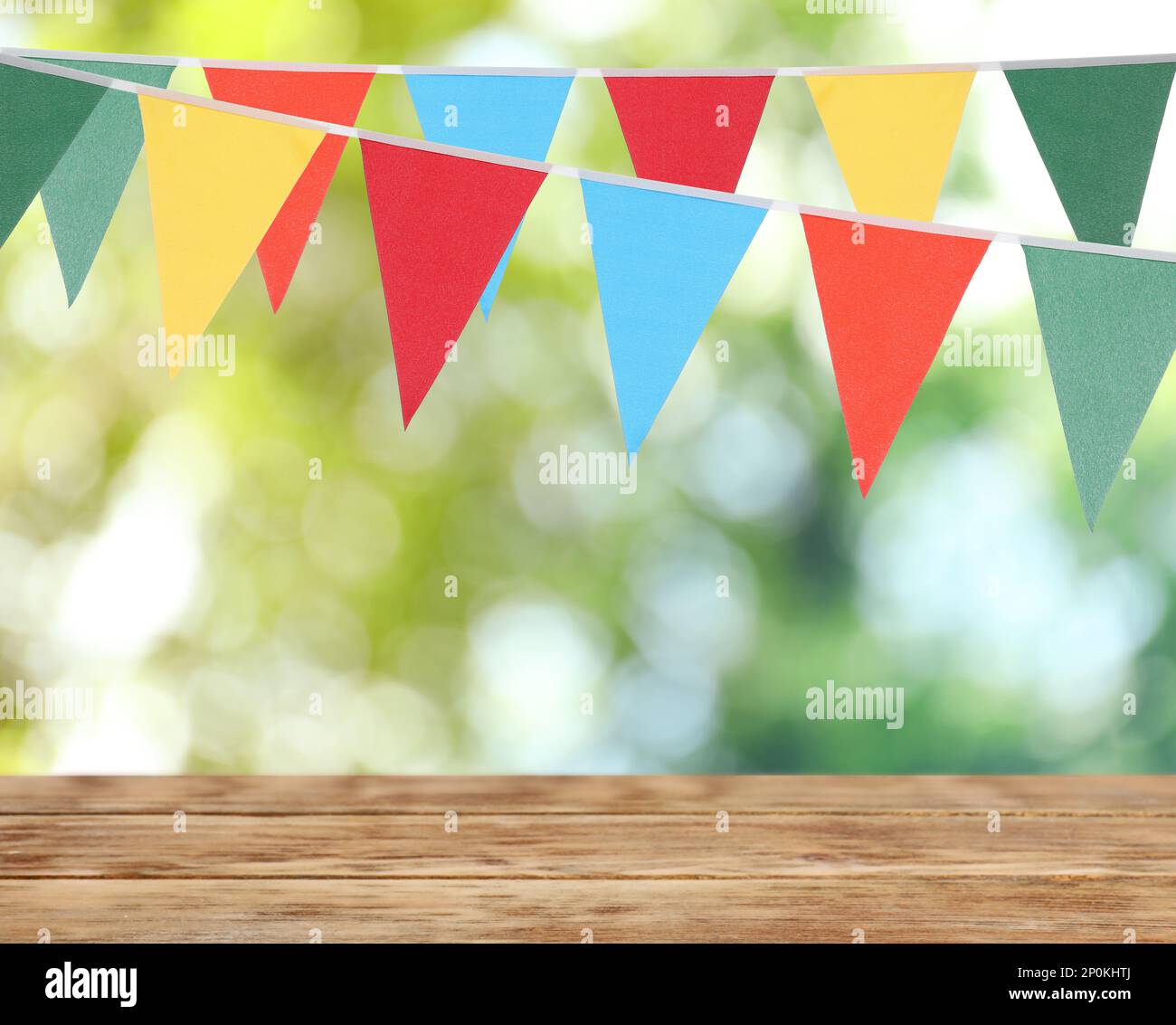 Empty wooden table and decorative bunting flags outdoors Stock Photo ...