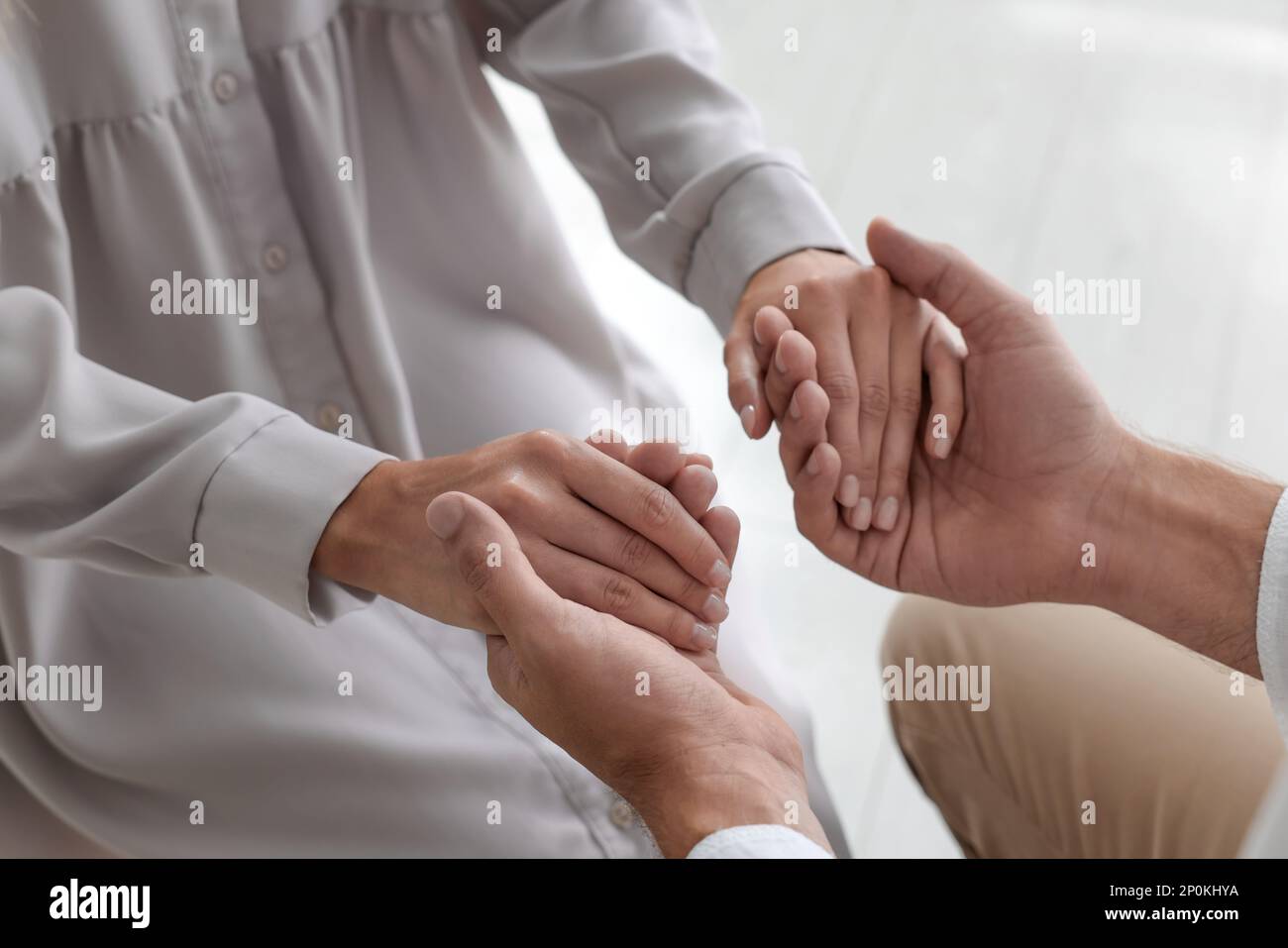 Religious people holding hands and praying together indoors, closeup ...