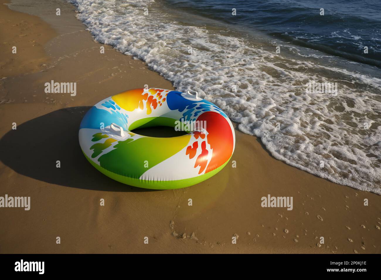 Bright inflatable ring on sandy beach near sea, space for text Stock ...