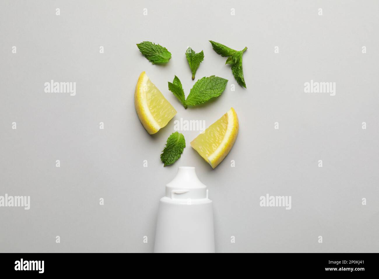 Blank tube of toothpaste with mint and lemon on white background, flat ...