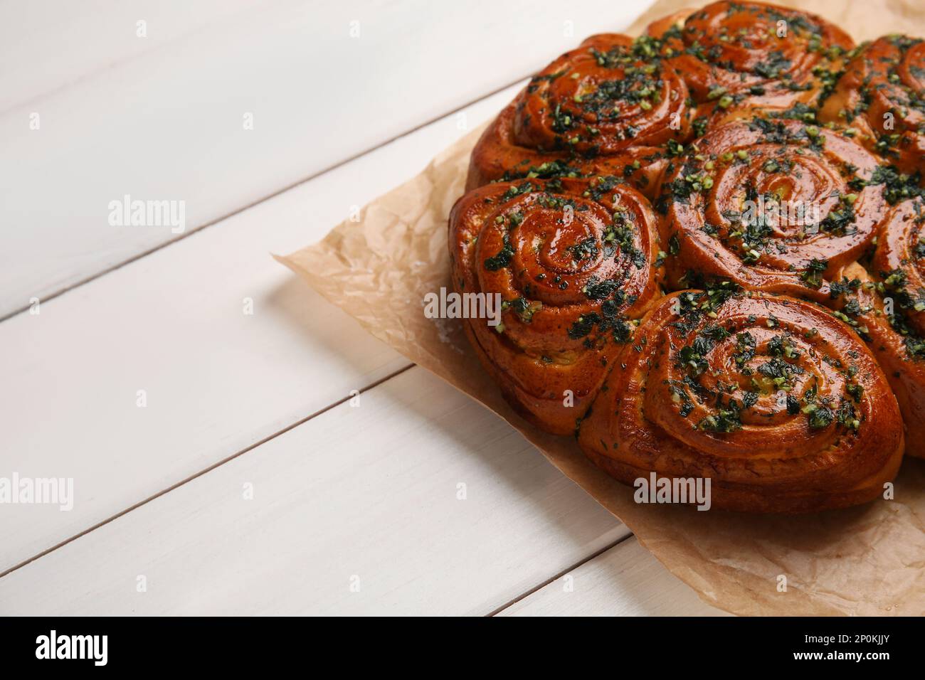 Traditional pampushka rolls with garlic and herbs on white wooden table ...