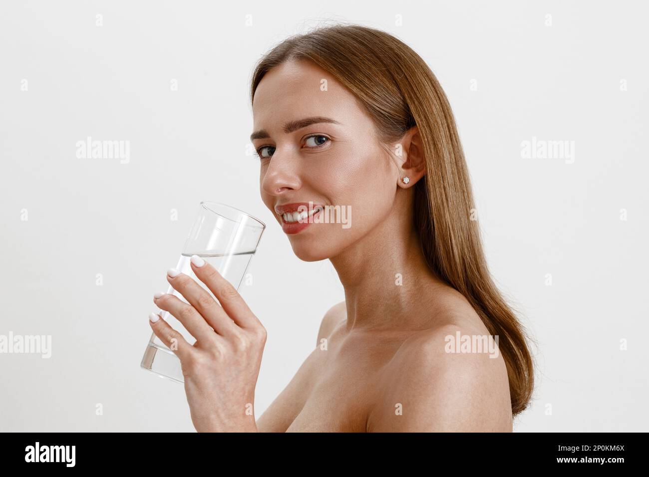 Smiling healthy woman holding water glass on a white studio background Stock Photo - Alamy