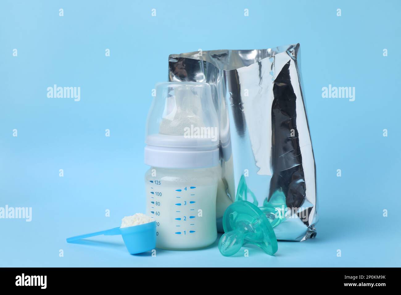 Bag of powdered infant formula, feeding bottle, scoop and pacifier on ...