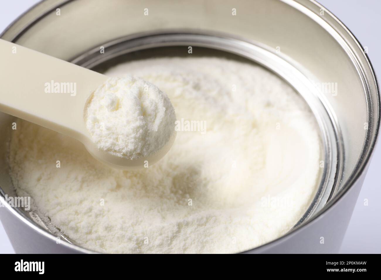 Scoop of powdered infant formula over can, closeup. Baby milk Stock ...