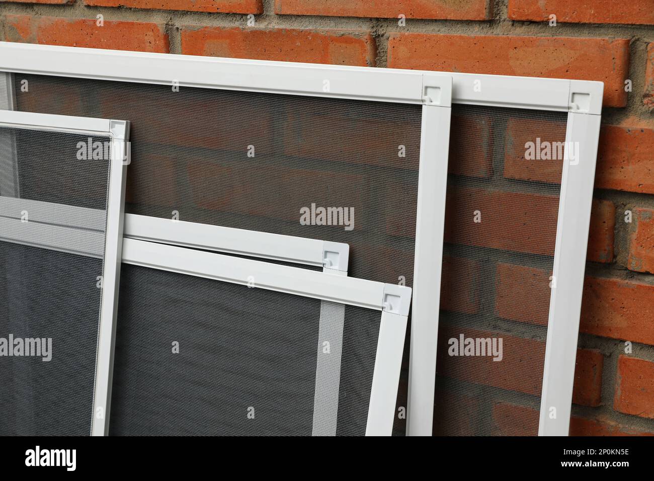 Set of window screens near brick wall Stock Photo - Alamy
