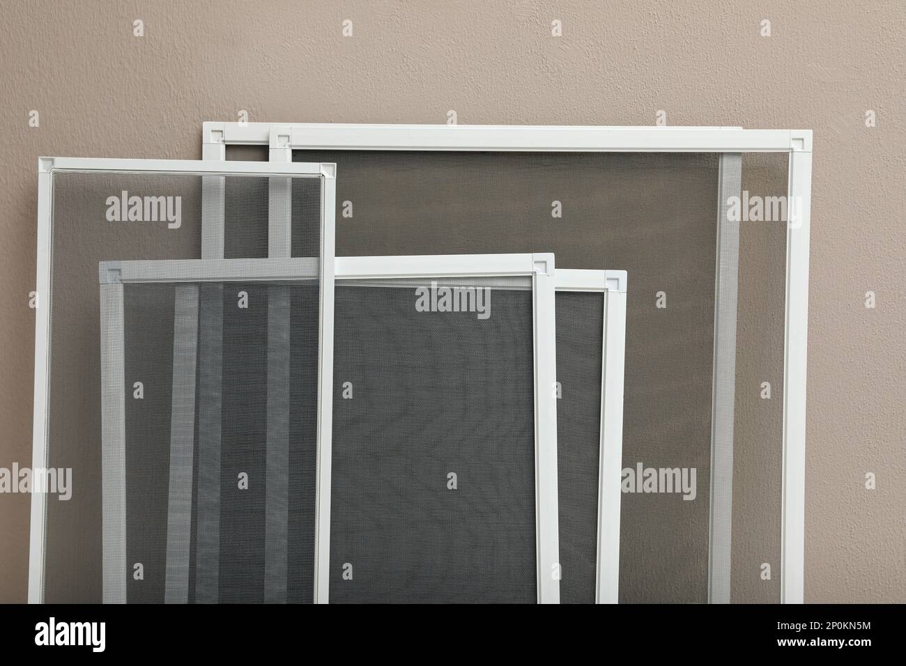 Set of window screens near beige wall Stock Photo - Alamy
