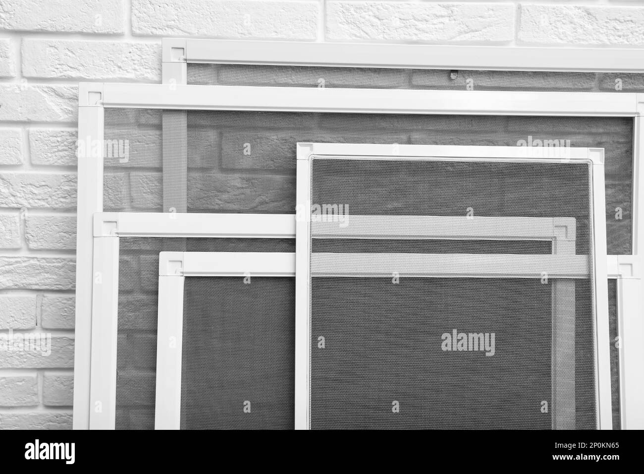 Set of window screens near white brick wall, closeup Stock Photo - Alamy