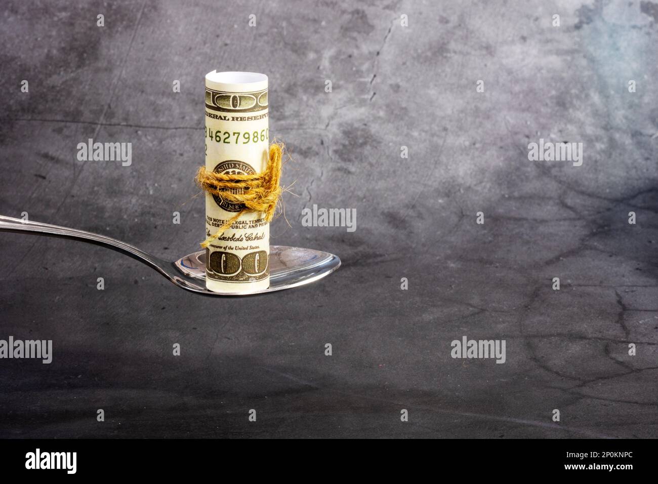 Dollar fake banknote in the spoon on a dark background, studio shoot ...