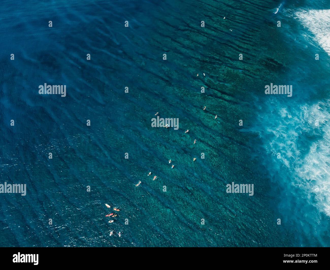 Aerial view of blue transparent ocean with surfers. Surfing spot in ...