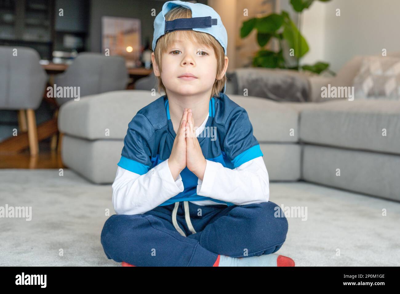Adorable little boy sitting on the floor of his home Stock Photo - Alamy