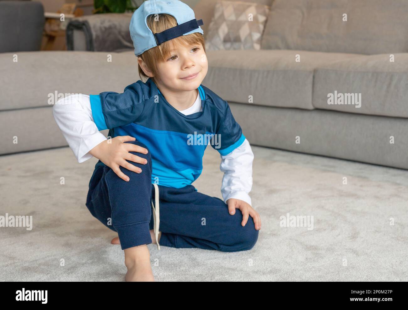Adorable little boy sitting on the floor of his home Stock Photo - Alamy