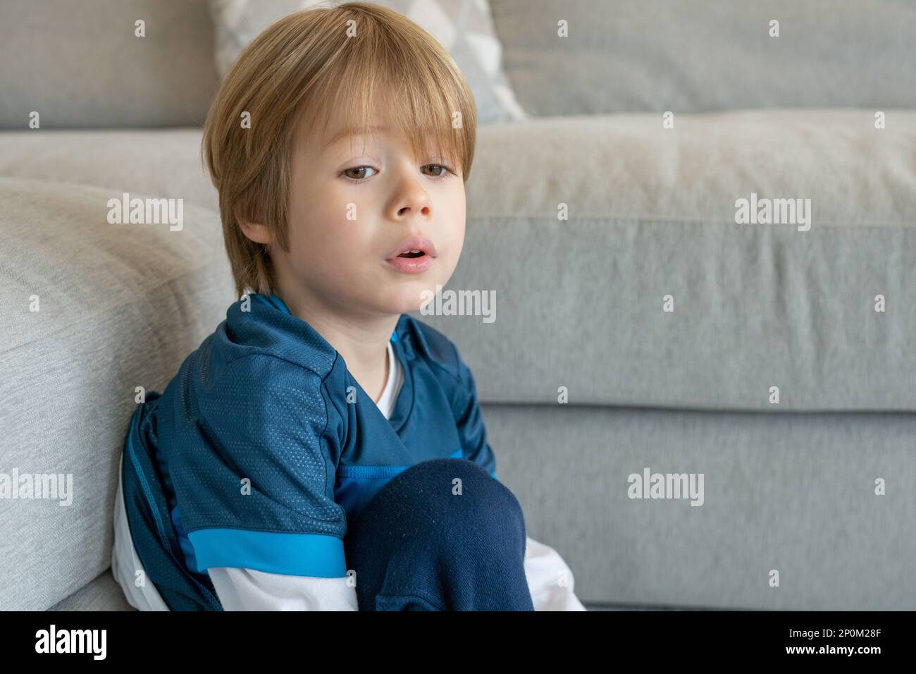 Adorable little boy sitting on the floor of his home Stock Photo - Alamy
