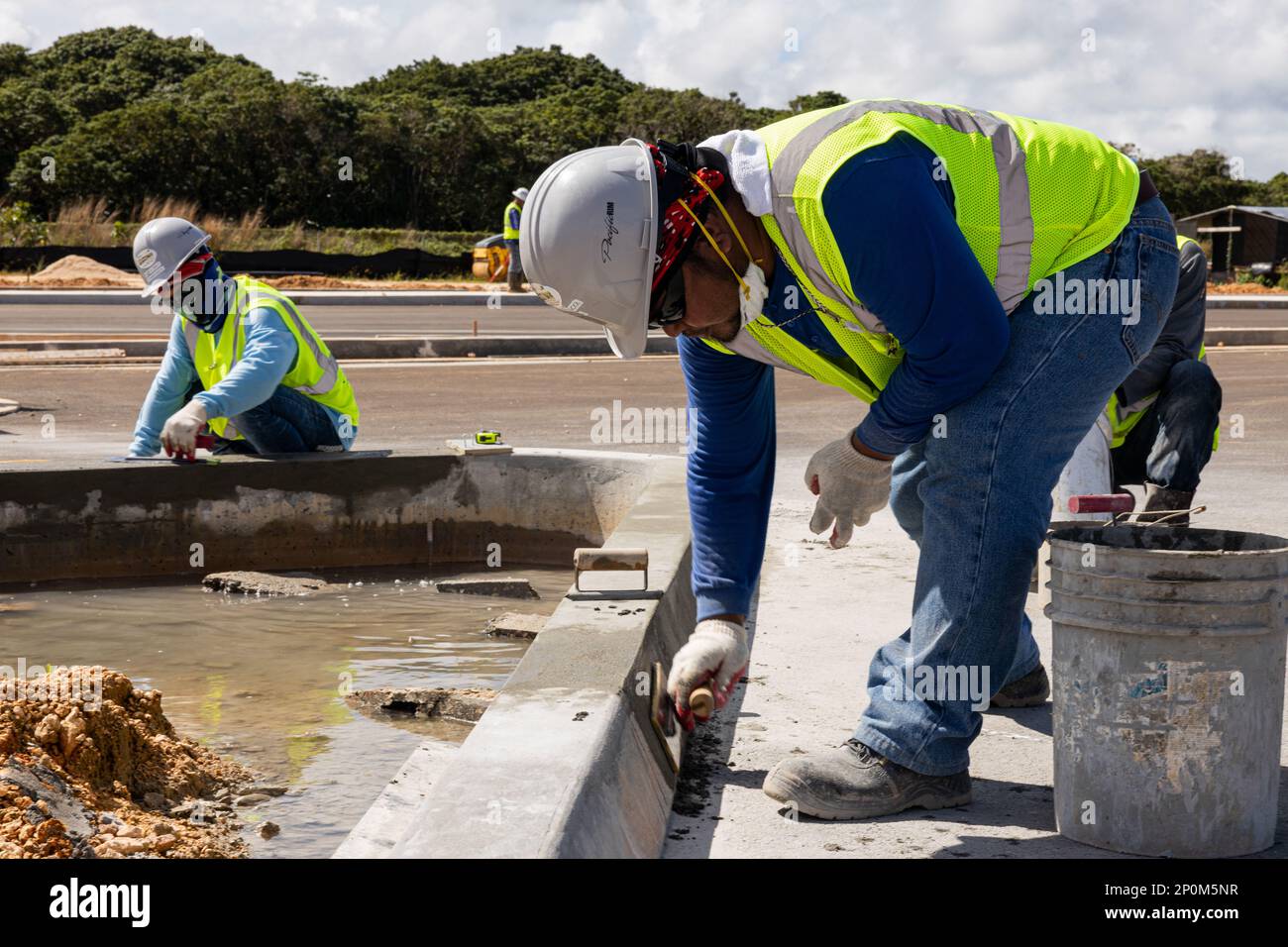 Construction workers smooth out concrete on the main cantonment site of ...