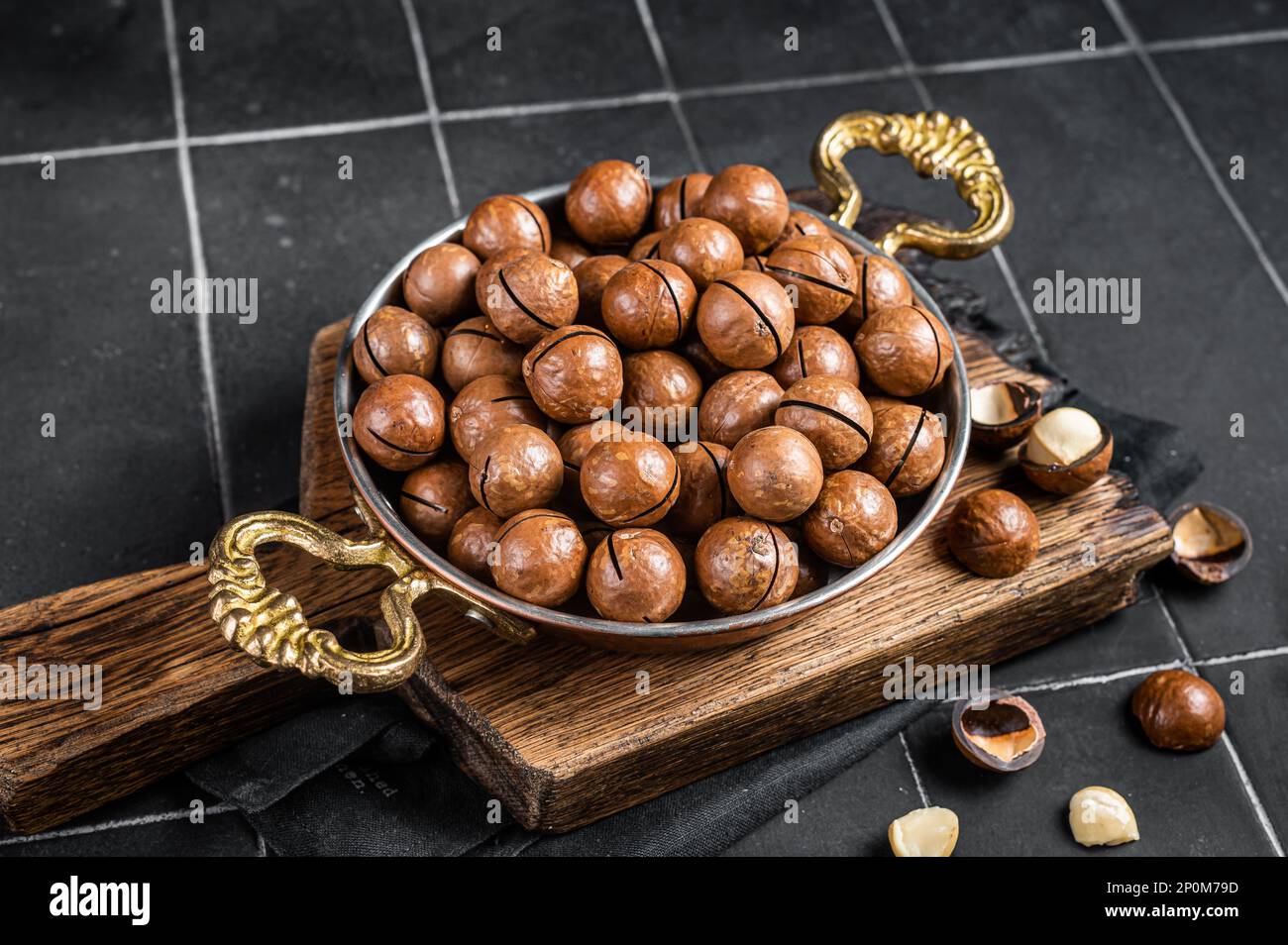 Macadamia nuts in a shell ready to eat. Black background. Top view ...