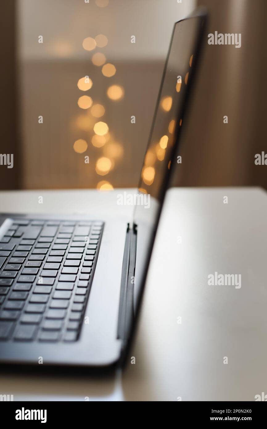 Close up of laptop keyboard with blank screen on a table by blurry ...