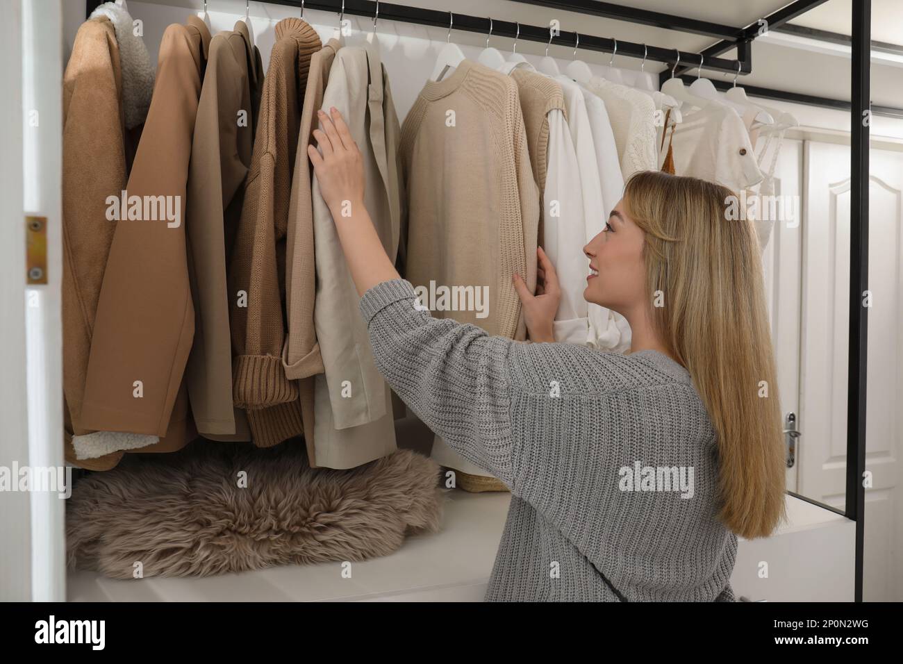 Young woman choosing outfit in dressing room Stock Photo - Alamy
