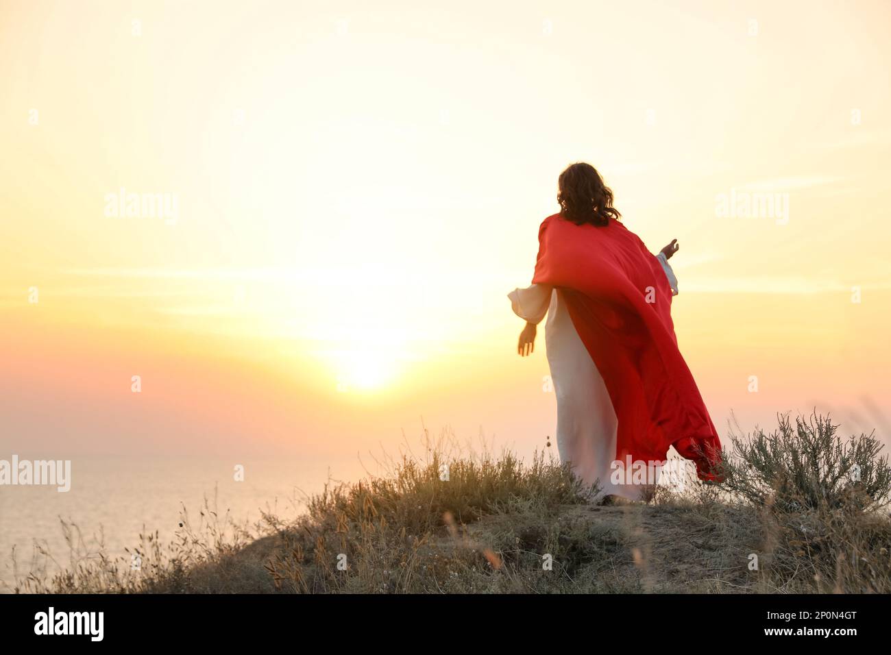Jesus Christ on hills at sunset, back view. Space for text Stock Photo - Alamy