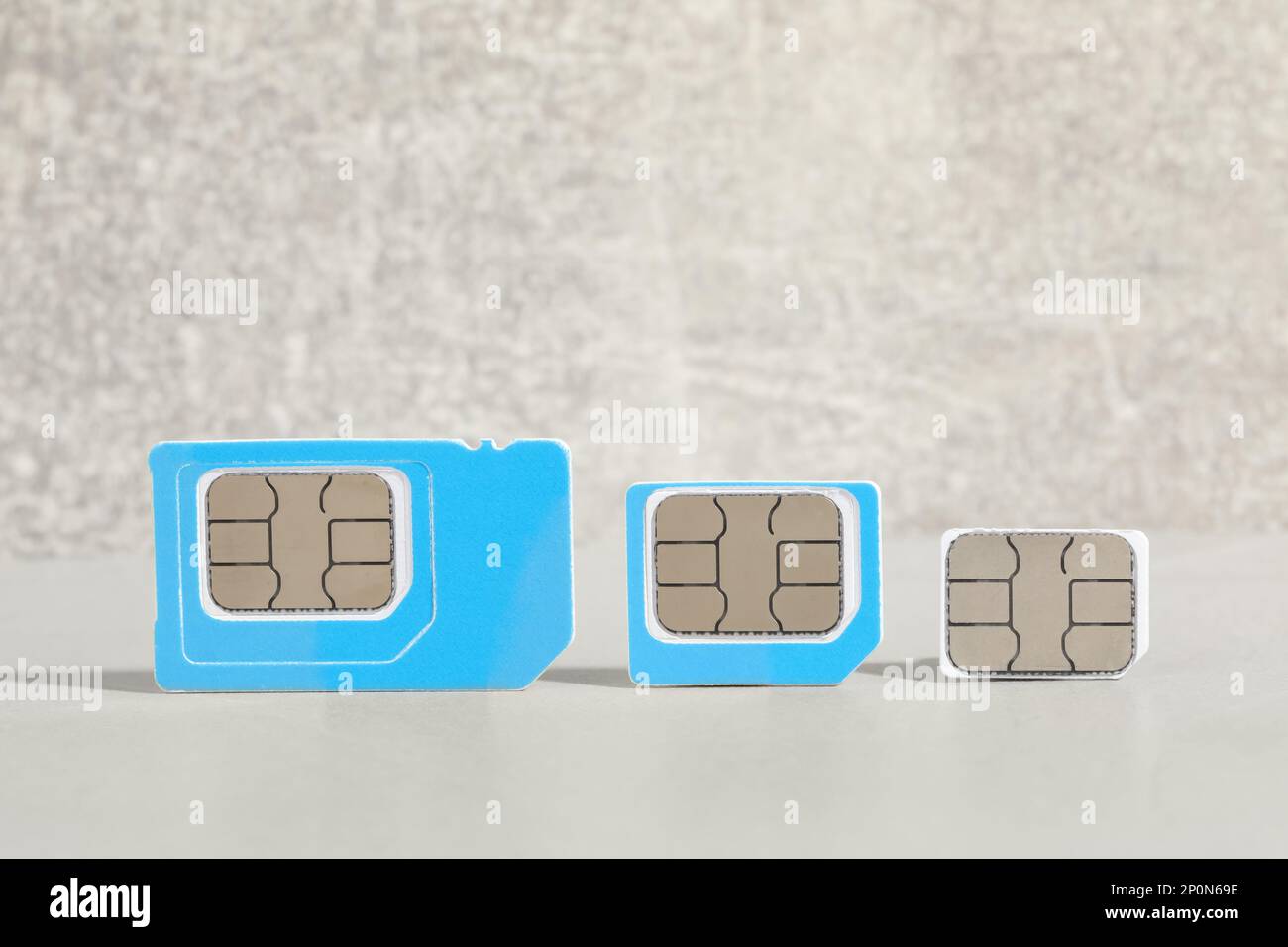 Different color SIM cards on light grey table. Space for text Stock ...