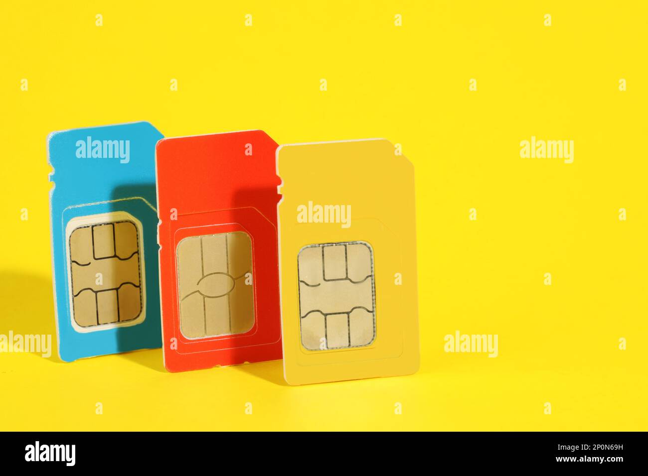 Different SIM cards on yellow background. Space for text Stock Photo ...
