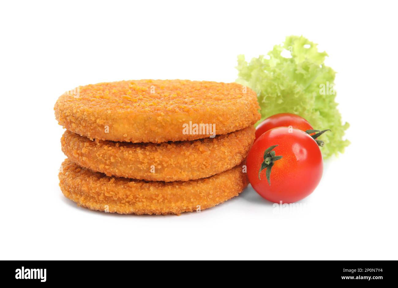 Uncooked breaded cutlets, tomatoes and lettuce on white background ...