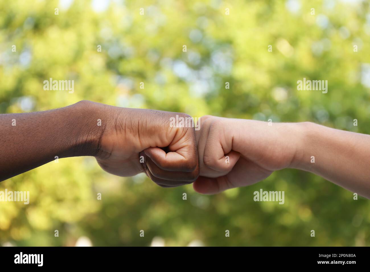 Men making fist bump outdoors, closeup view Stock Photo - Alamy