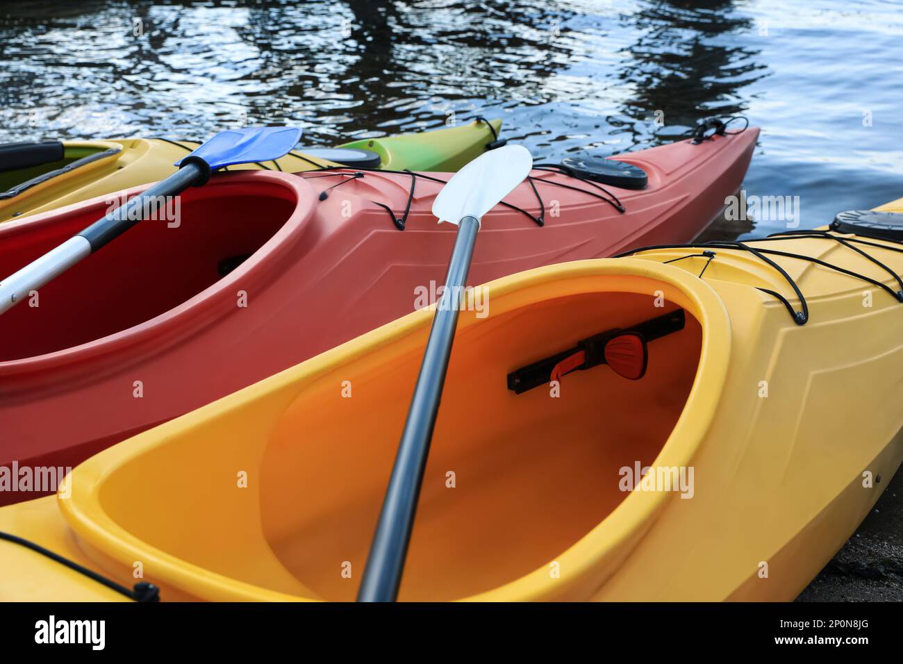 Modern kayaks with paddles on river, closeup. Summer camp activity ...
