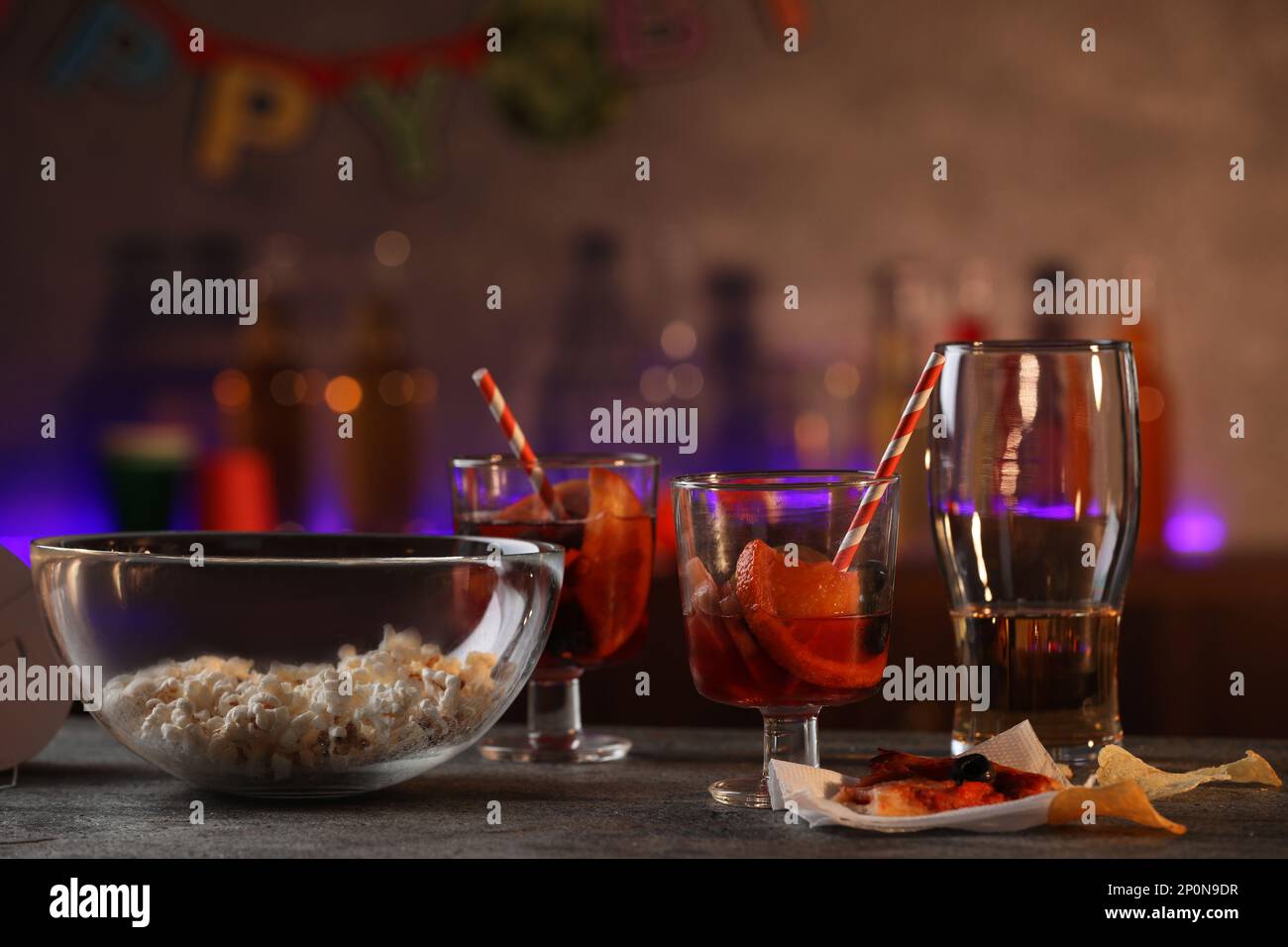 Messy table with drinks and food leftovers indoors. After party chaos ...