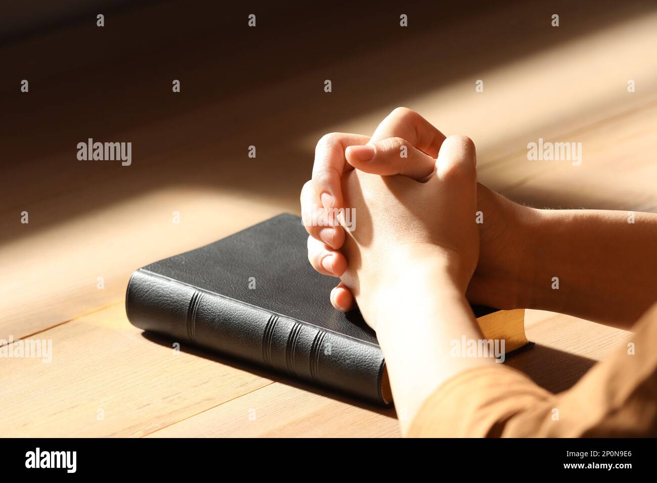 Religious woman praying over Bible indoors, closeup Stock Photo - Alamy