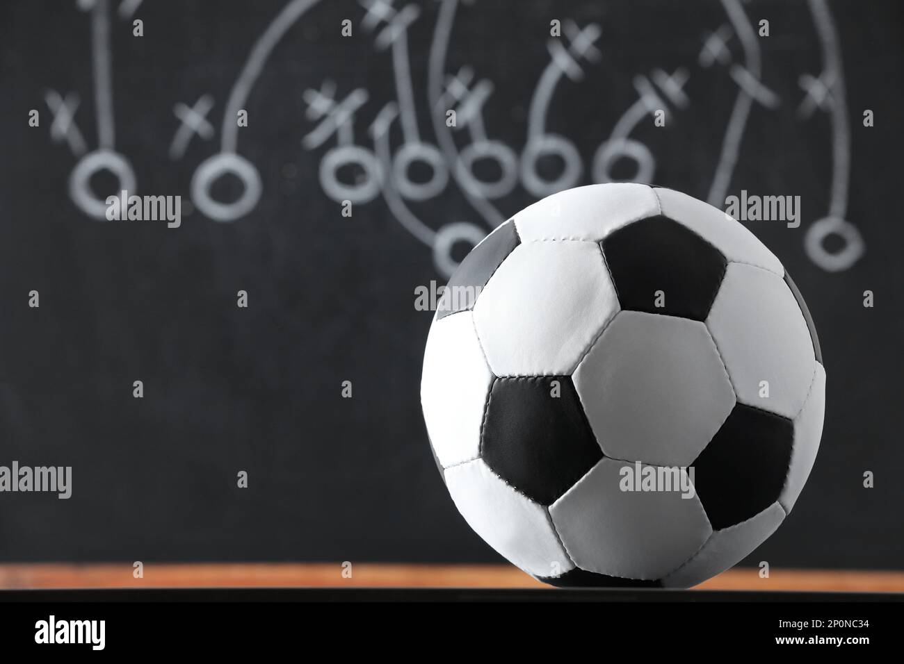 Football ball against blurred game scheme. Space for text Stock Photo ...