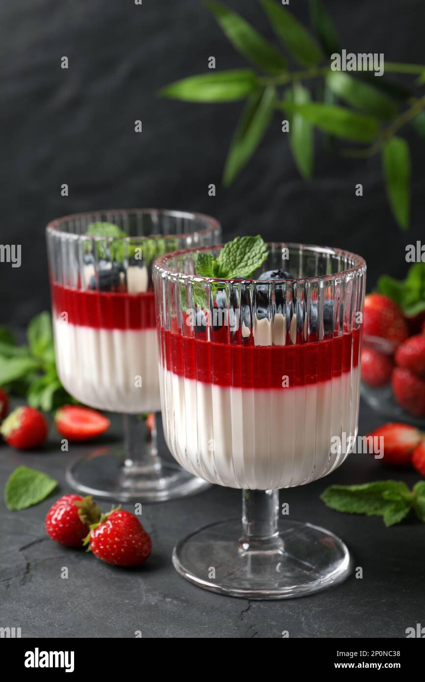 Delicious panna cotta with fruit coulis and fresh berries on dark grey ...