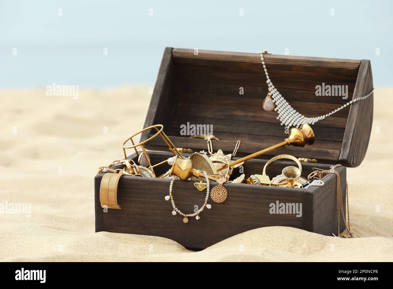 Open wooden treasure chest on sandy beach Stock Photo - Alamy