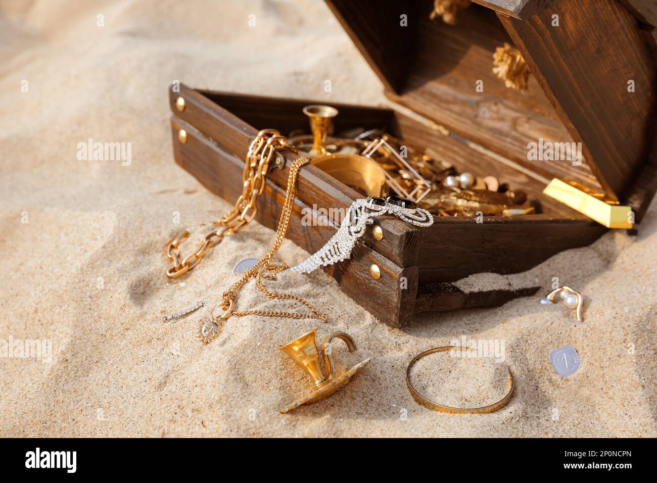 Open wooden chest with treasures on sand Stock Photo - Alamy