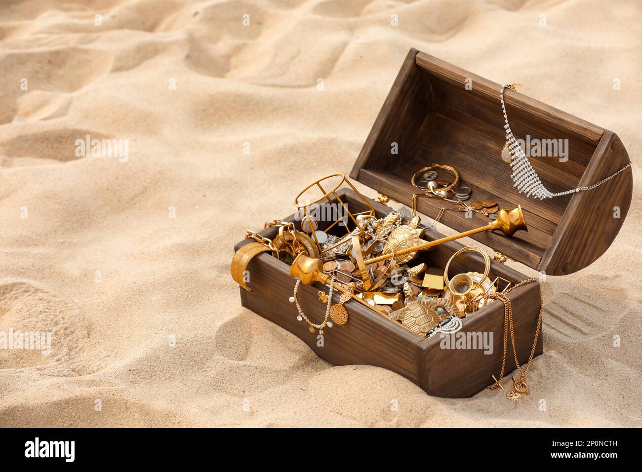 Open wooden treasure chest on sand, space for text Stock Photo - Alamy