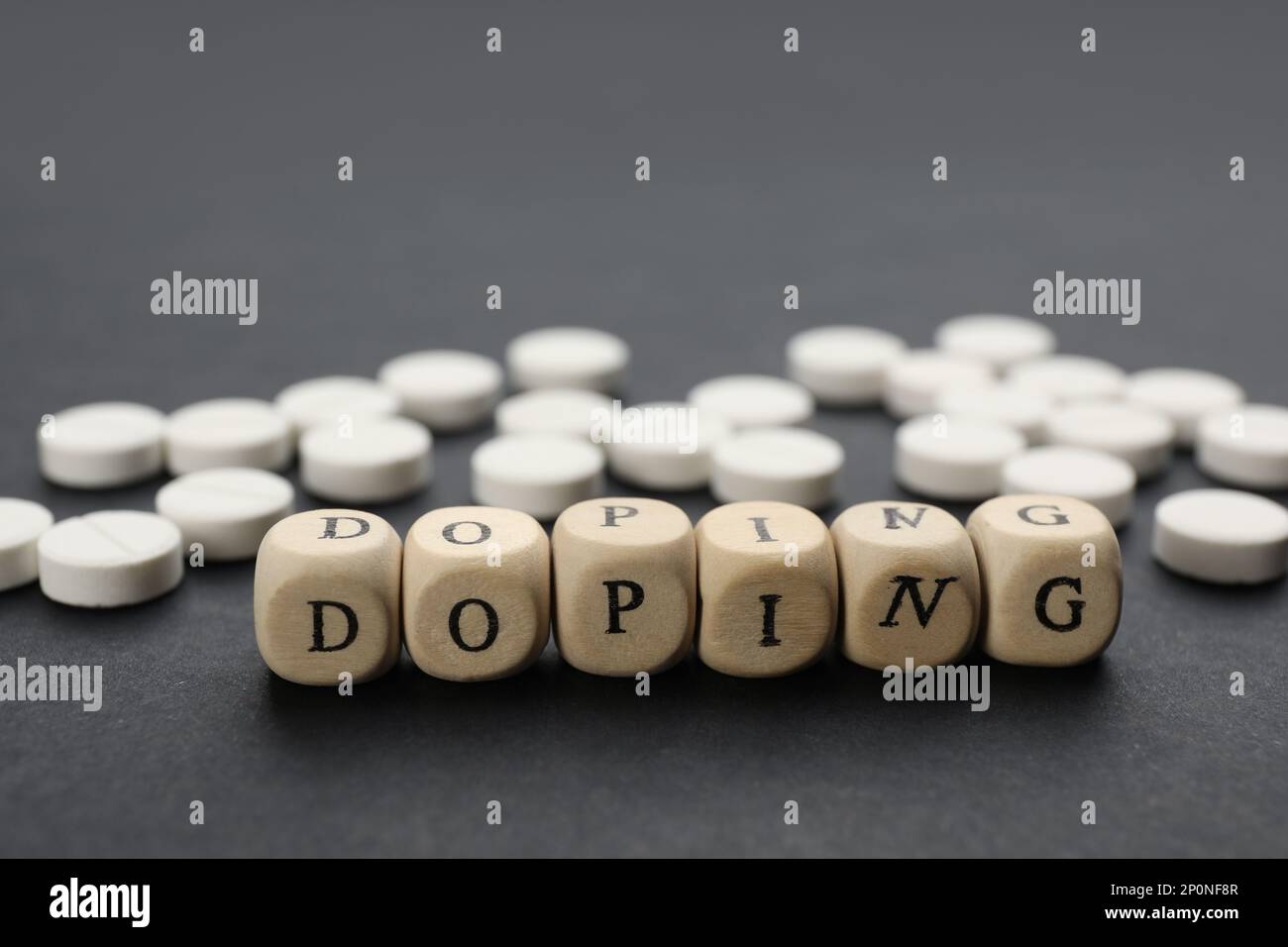 Wooden cubes with word Doping and drugs on black background, closeup ...