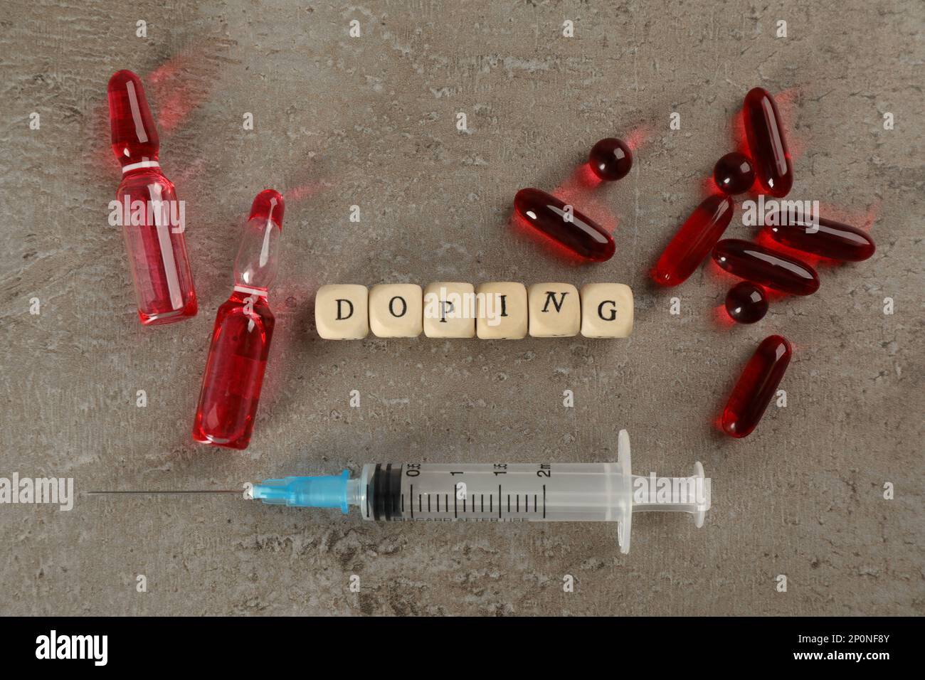 Wooden cubes with word Doping and drugs on grey background, flat lay ...
