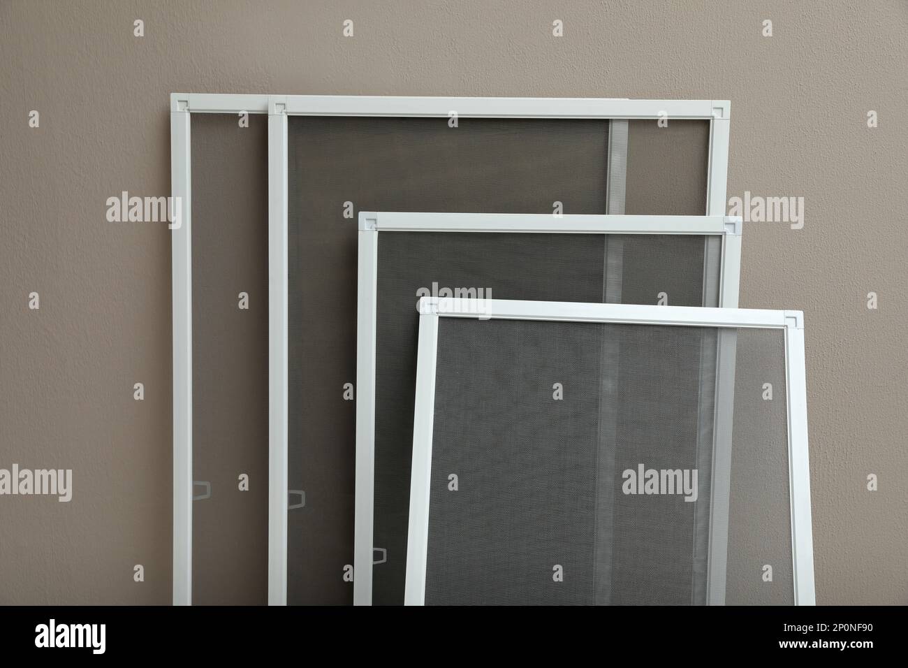 Set of window screens near beige wall Stock Photo - Alamy