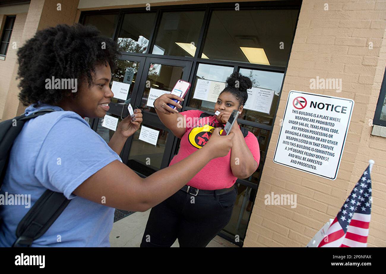 Jayla Harris, left, and Devin Hogue pose for photos with their early voting stickers outside the ...