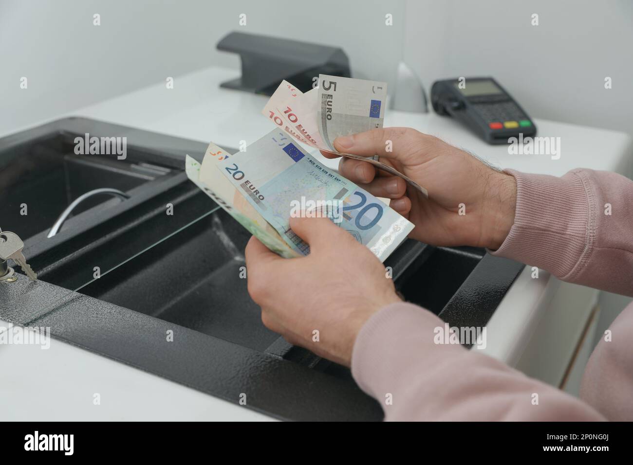 Man with money at cash department window, closeup. Currency exchange ...