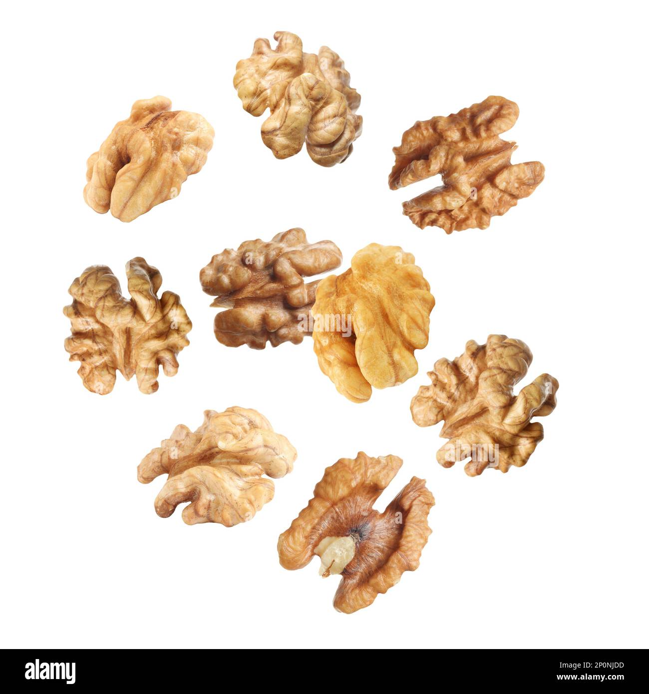 Halves of walnuts falling on white background Stock Photo - Alamy