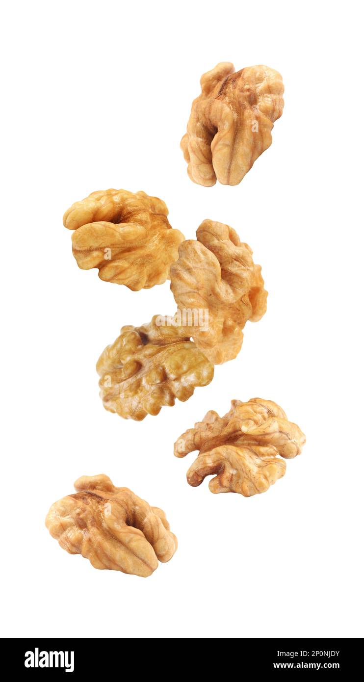 Halves of walnuts falling on white background Stock Photo - Alamy