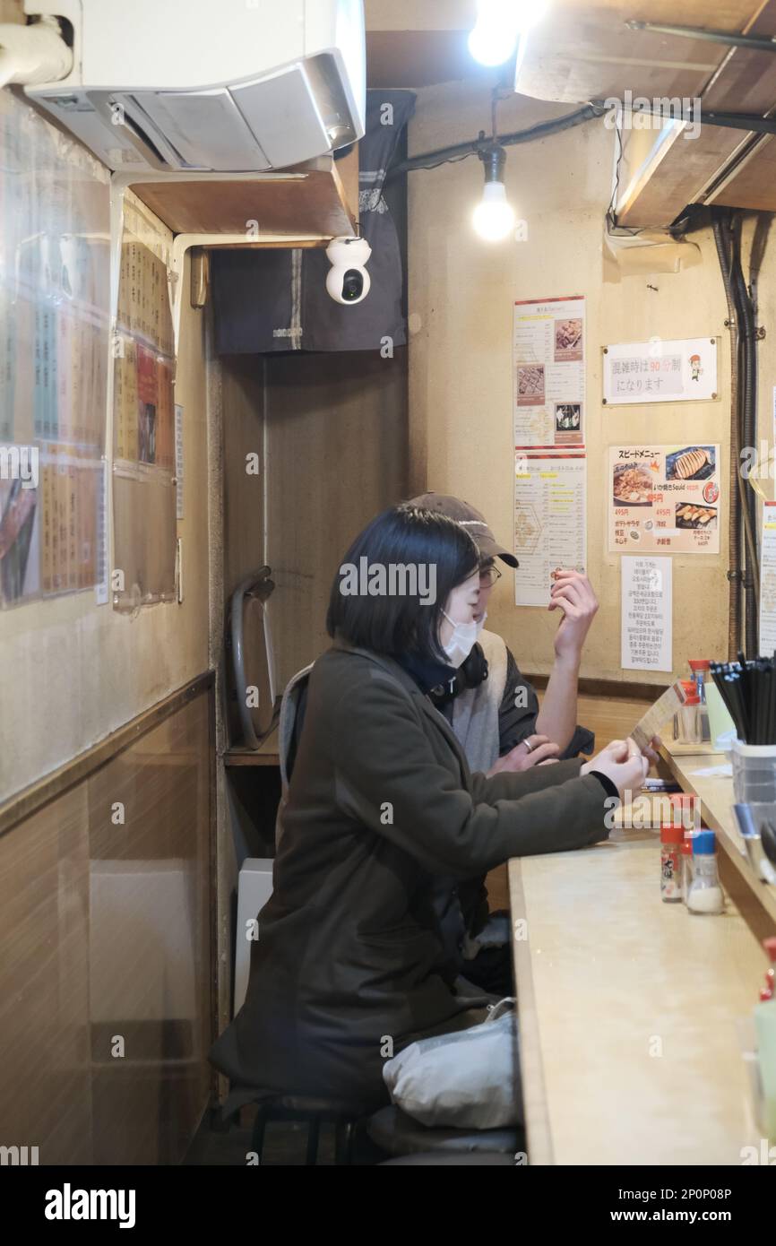 People eating in small alleyway restaurants in Shinjuku, Japan Stock ...