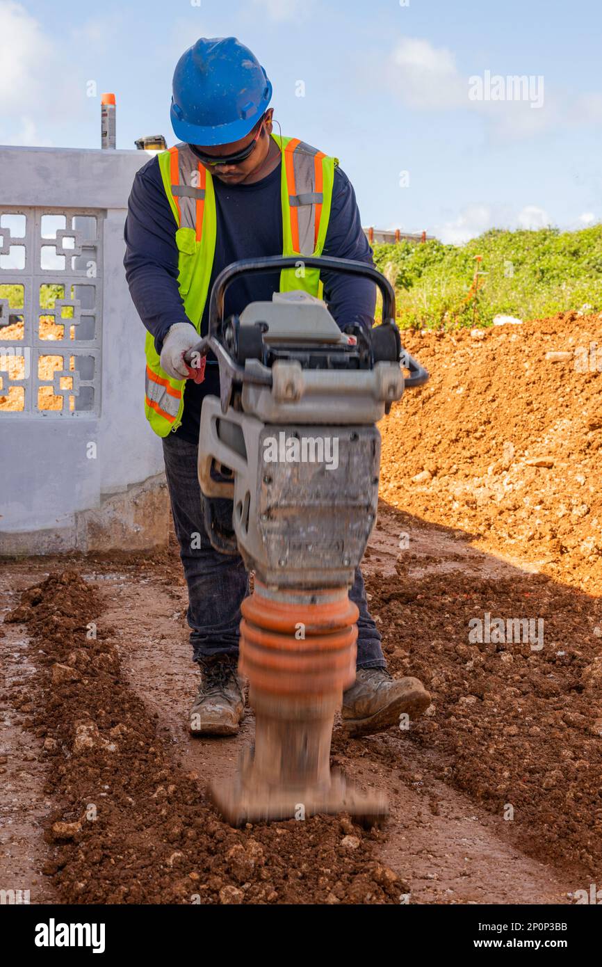 A construction worker uses a compactor for the construction of a ...