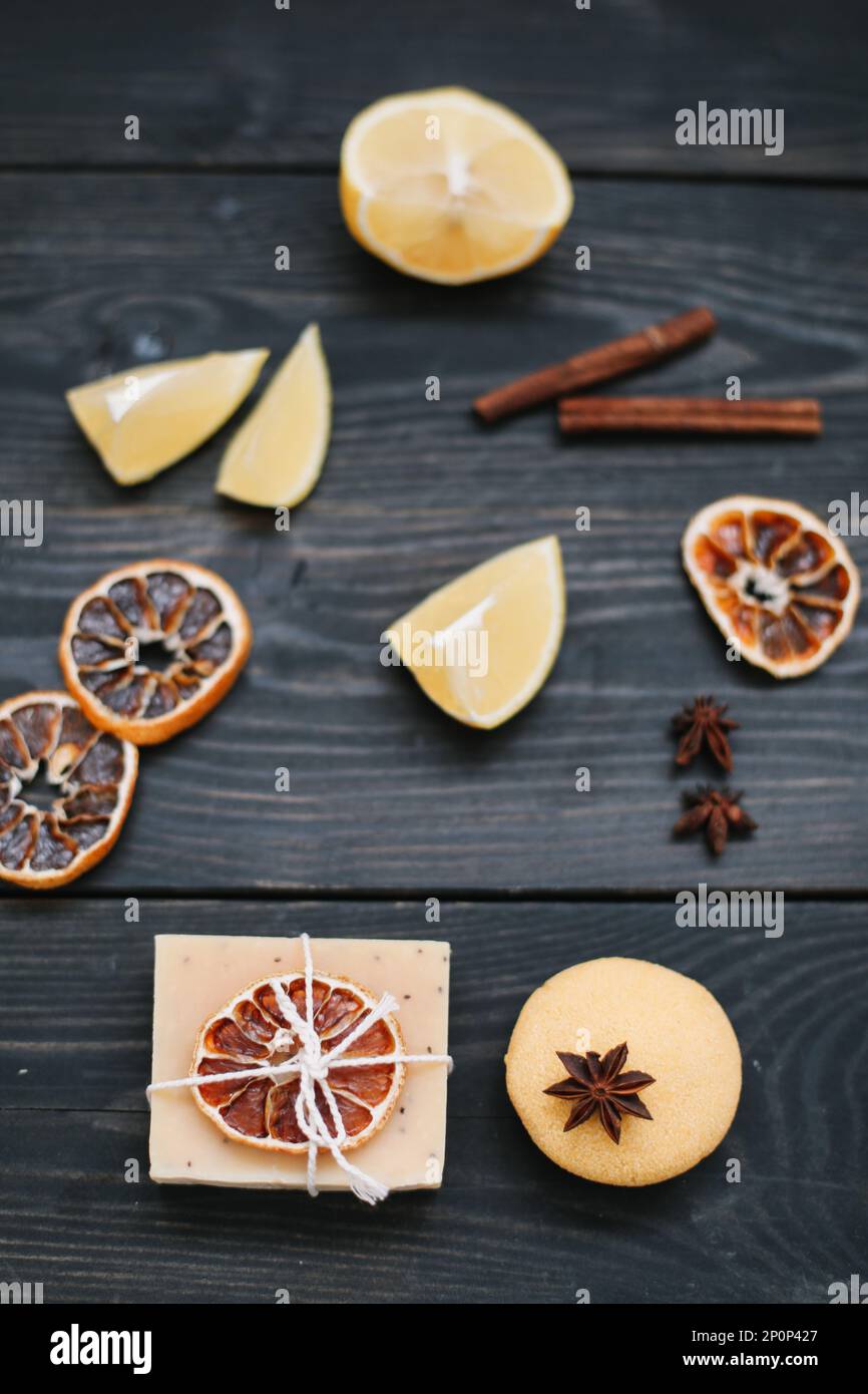 Handmade soap bars and citrus fruit on dark table top view. Piece of ...