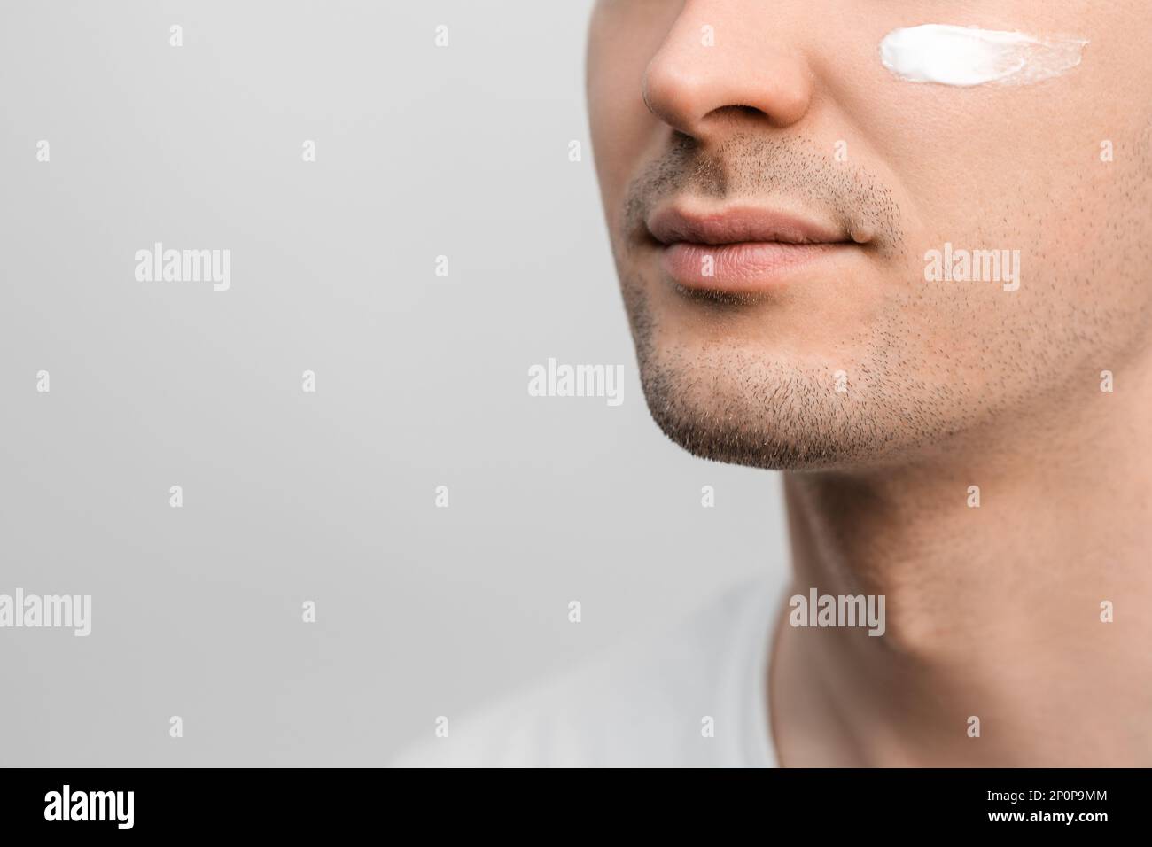A portrait of a handsome man with a stubble in a white t-shirt, sample ...