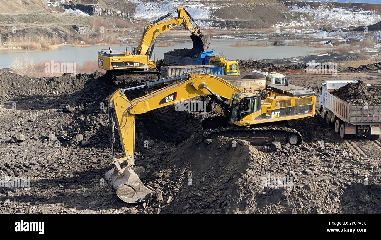 Excavators are loading continuously the trucks, working at a huge ...